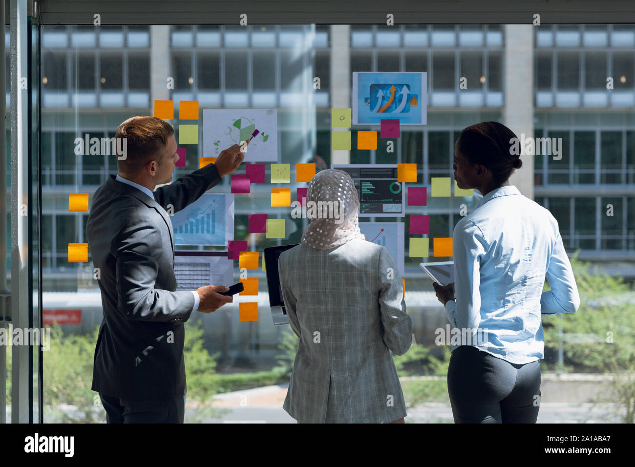 Business people discussing over sticky notes in office Stock Photo - Alamy