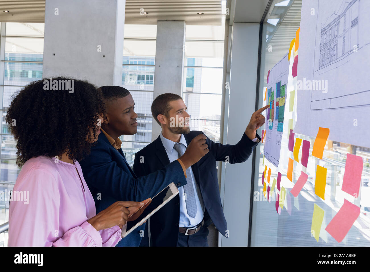 Three young business people in discussion in a modern office Stock ...