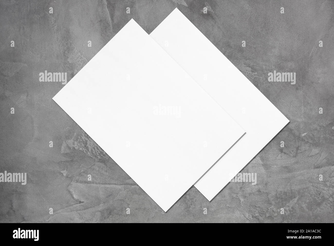 Two empty white rectangle poster mockups lying diagonally on top of ...
