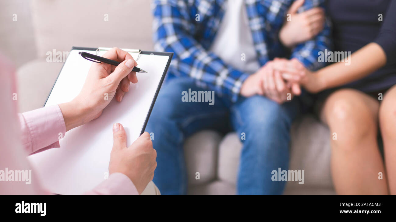 Therapist writing in notepad, couple bonding on background Stock Photo ...