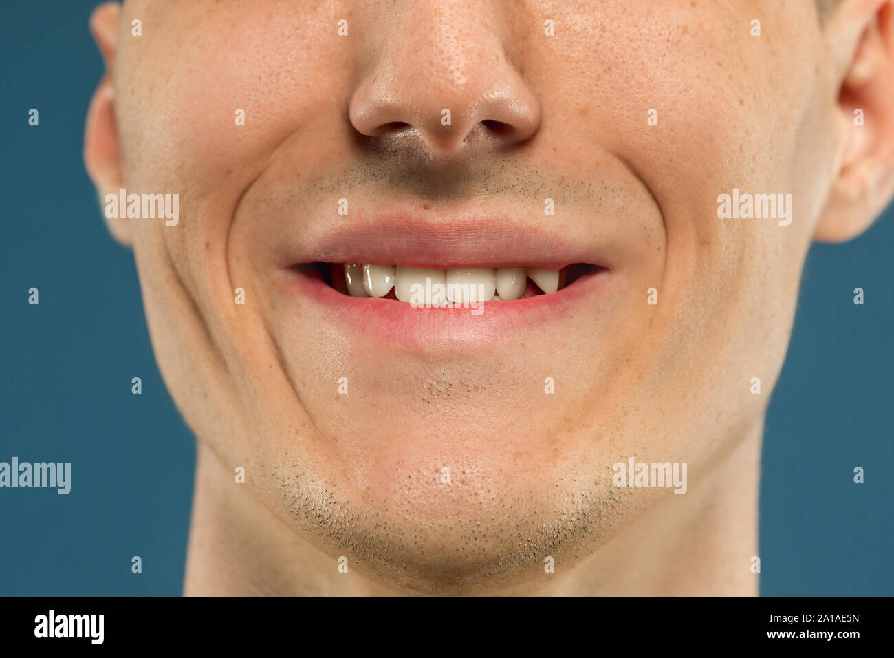 Caucasian young man's close up shot on blue studio background ...