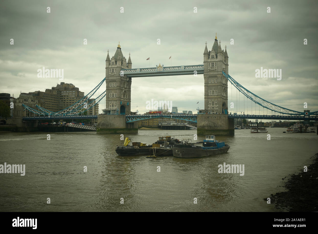 Tower bridge, with dark grey sky and boats Stock Photo - Alamy