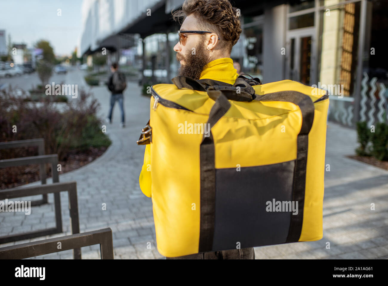 Delivery Man standing with yellow thermo backpack for food delivery ...