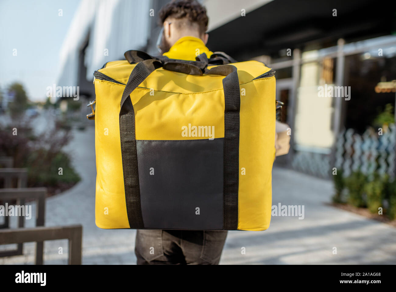 Delivery Man standing with yellow thermo backpack for food delivery ...