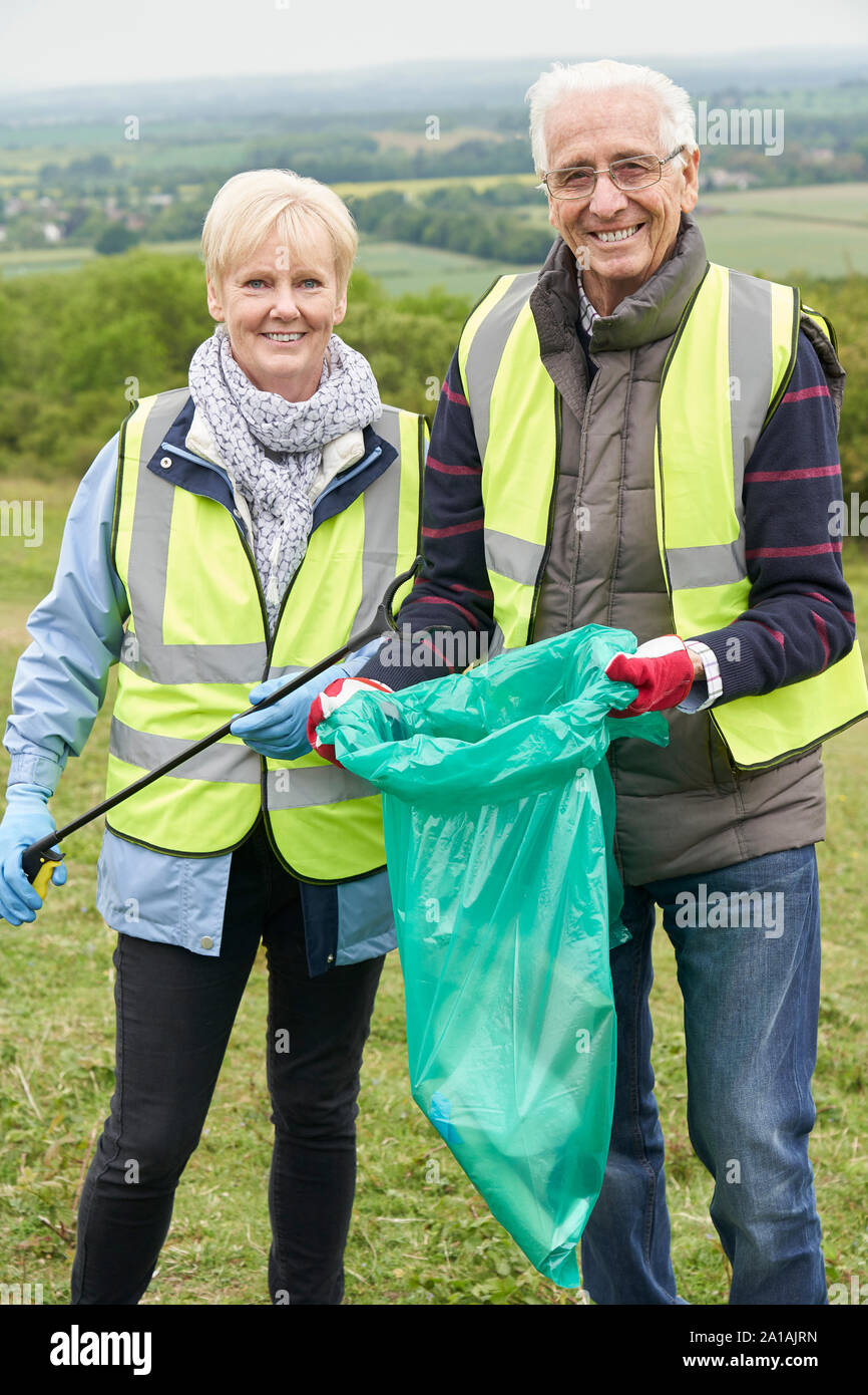 Portrait Of Helpful Senior Couple Collecting Litter In Countryside ...