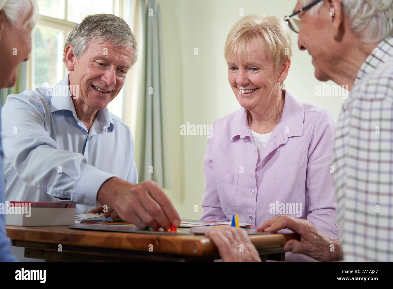 Group Of Retired Friends Playing Board Game At Social Club Stock Photo ...