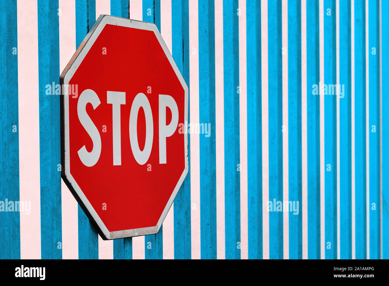 Stop sign, red hexagonal traffic road signage on blue gate Stock Photo ...