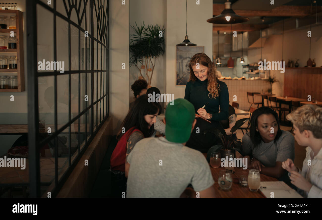 Customers ordering food from a bistro waitress in the evening Stock ...