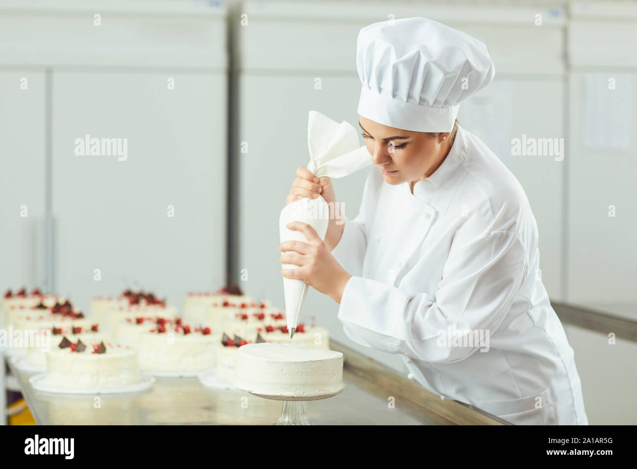 Confectioner decorating cake in pastry shop Stock Photo - Alamy
