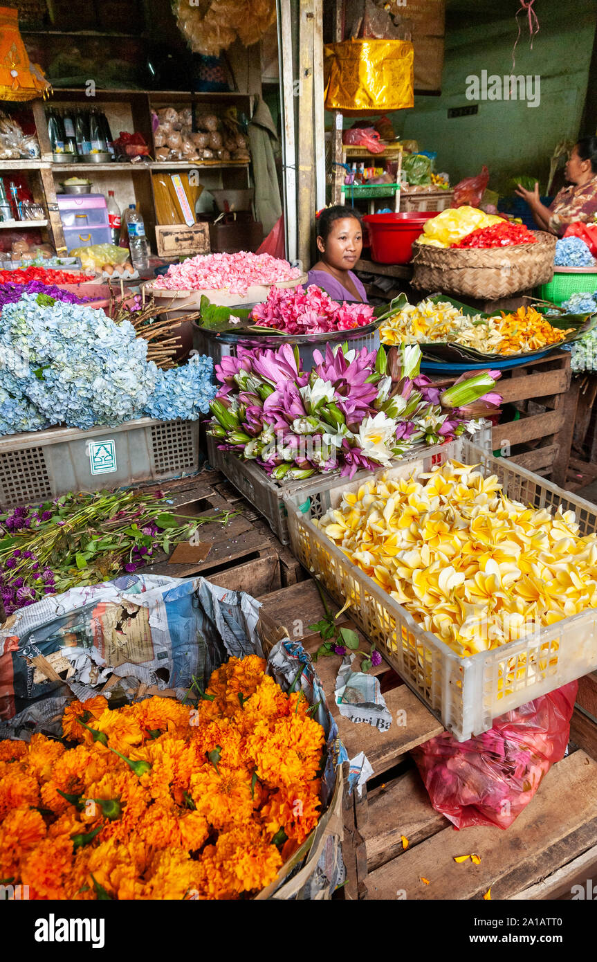 Woman selling flowers to decorate religious offerings, at the Pasar ...
