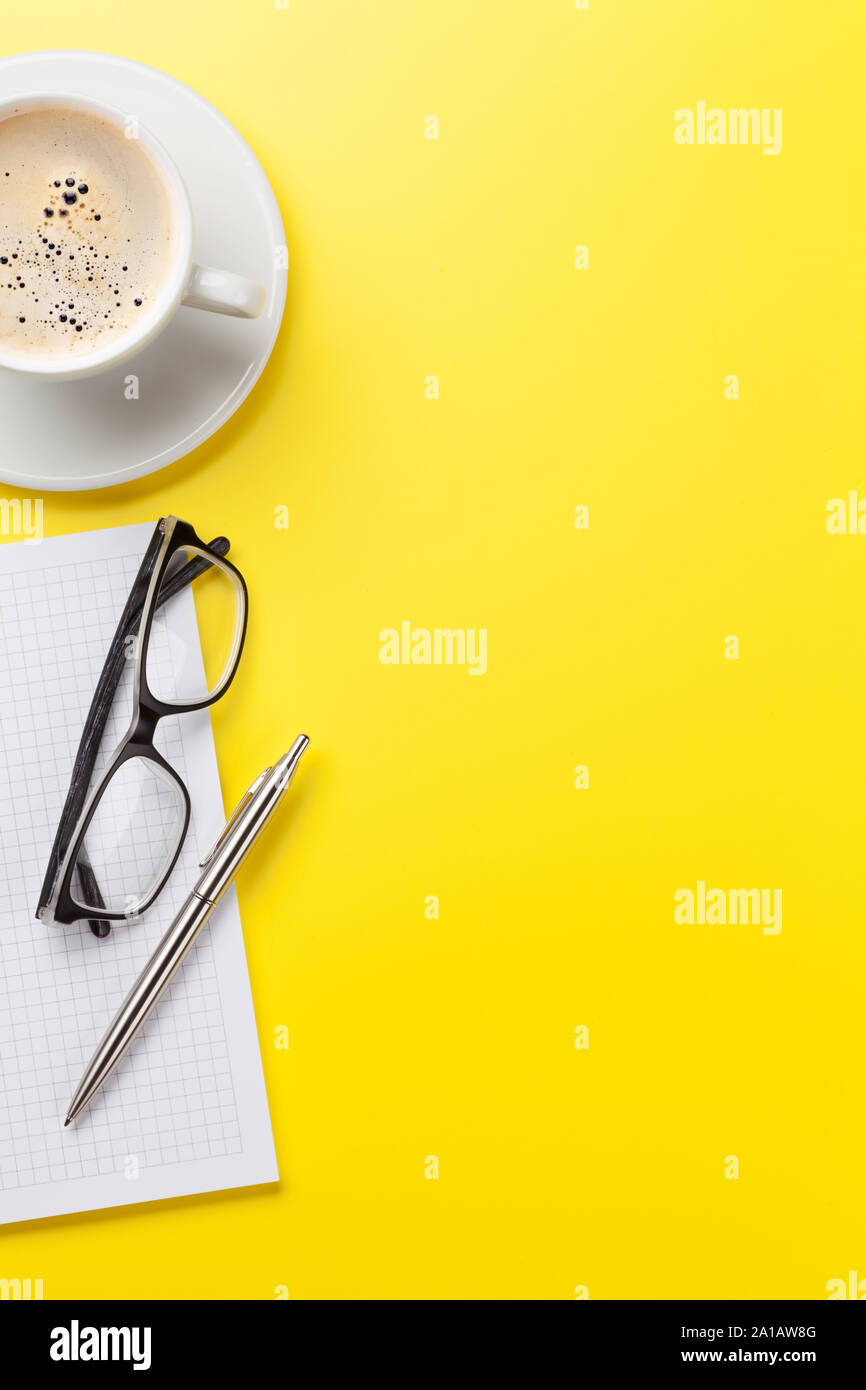 Office yellow workplace backdrop with coffee cup and supplies. Flat lay ...