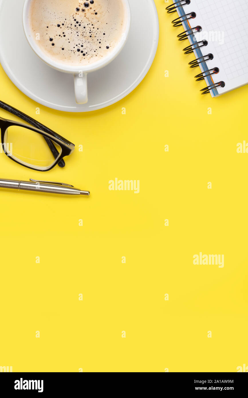 Office yellow workplace backdrop with coffee cup and supplies. Flat lay ...