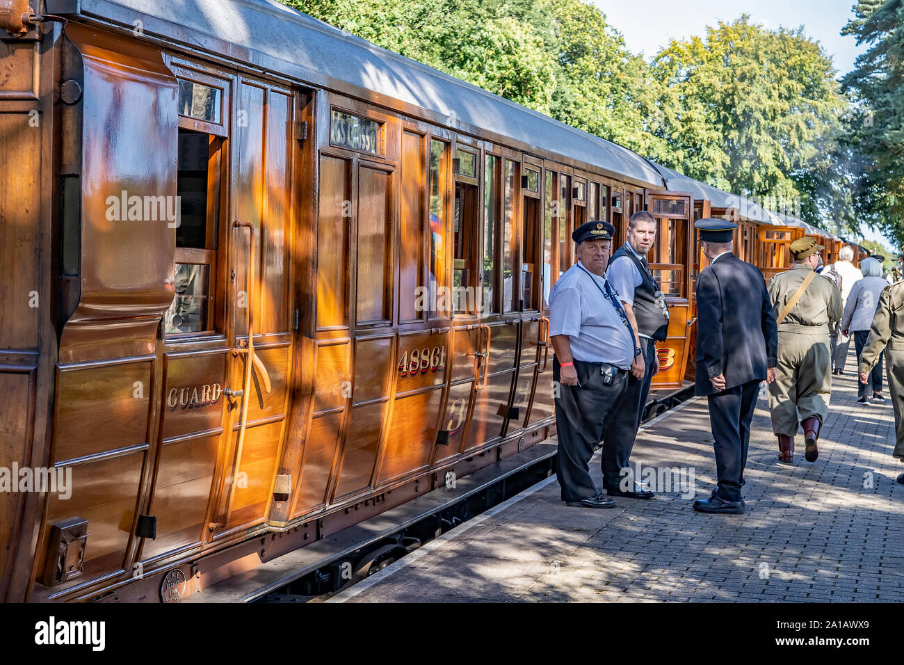 Train conductors next to a traditional wooden train carriage on Holt ...