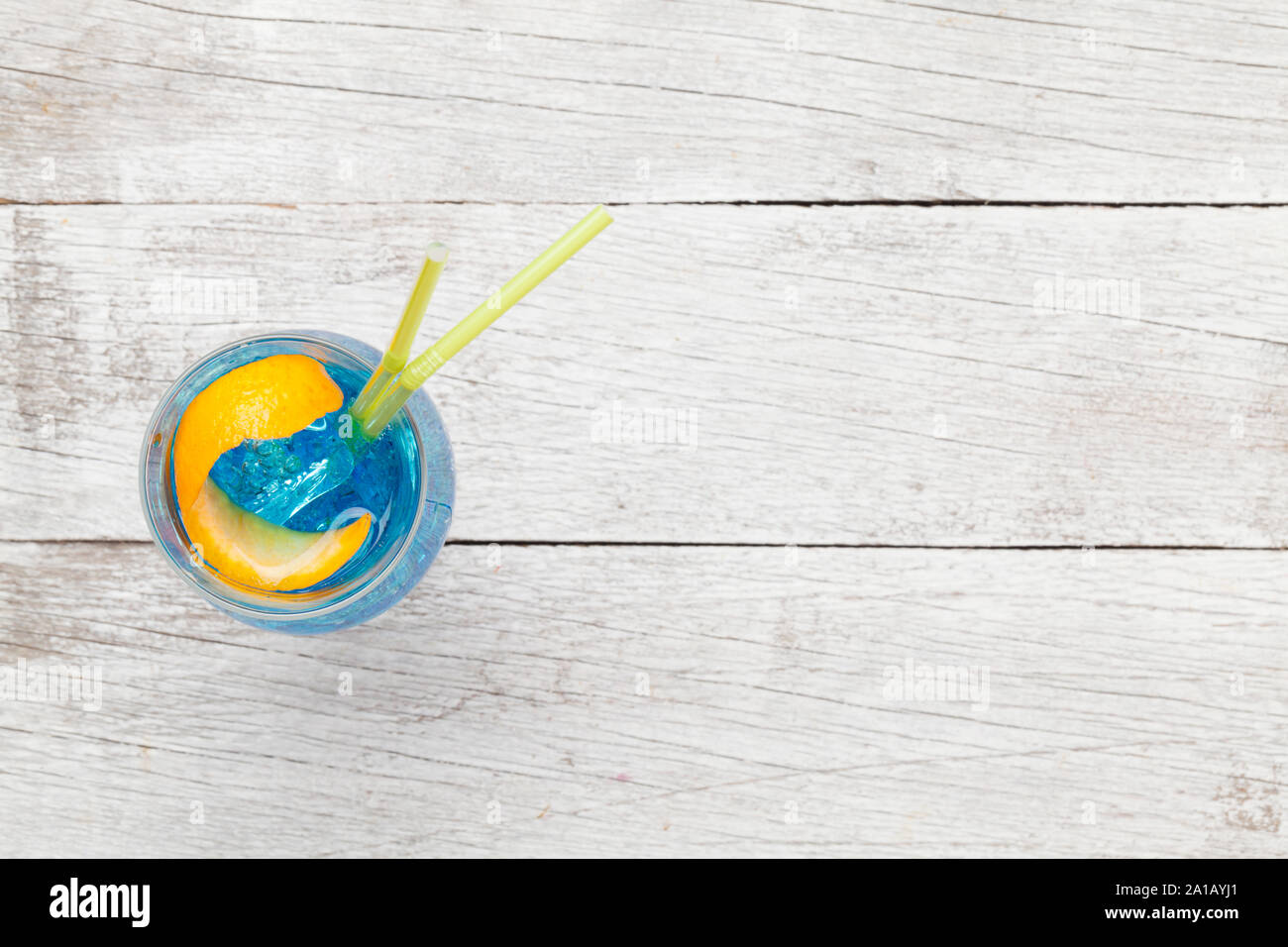 Classic blue lagoon cocktail on white wooden table. Top view with copy ...