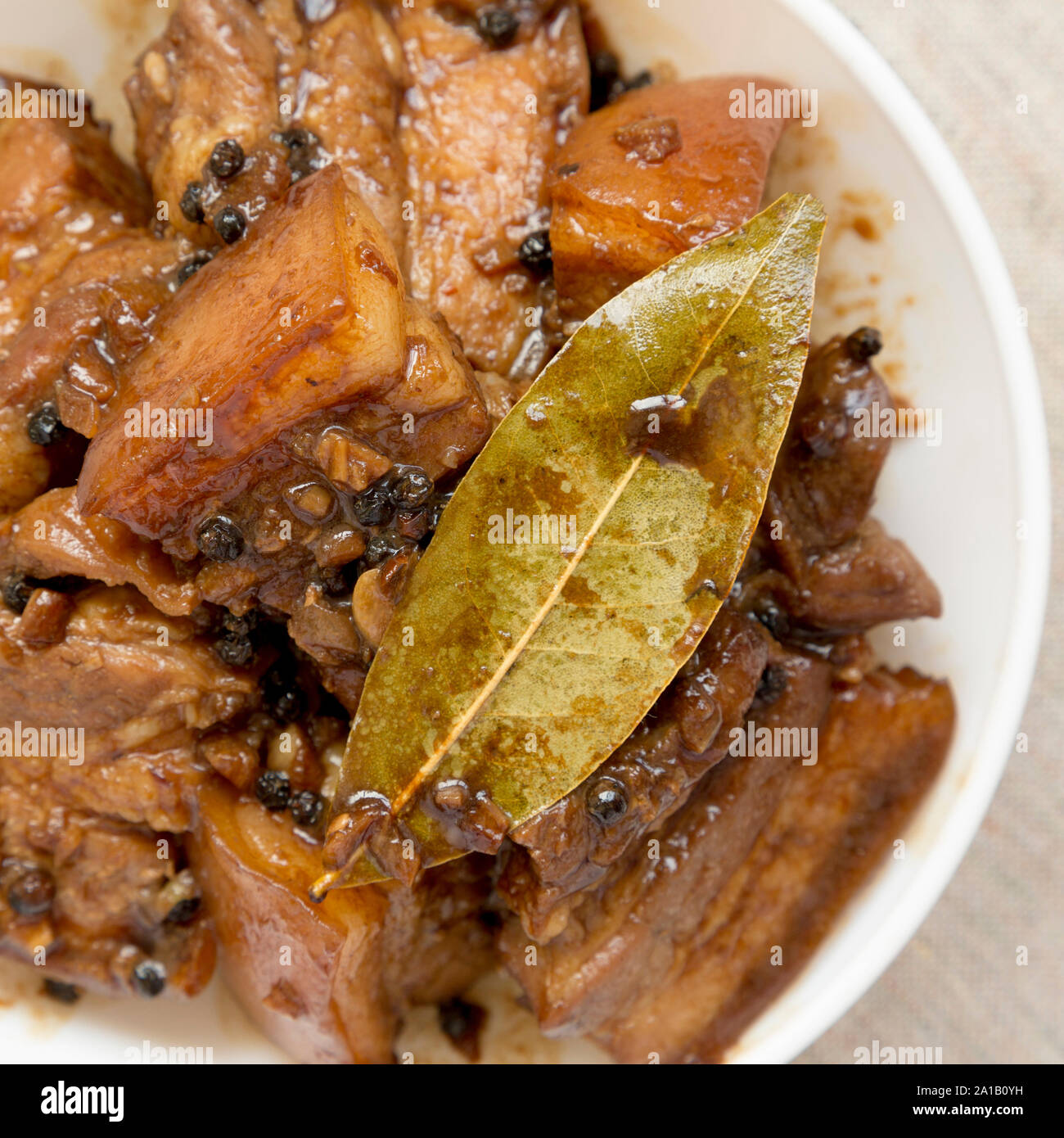 Homemade Filipino Adobo Pork in a white bowl, view from above. Flat lay ...