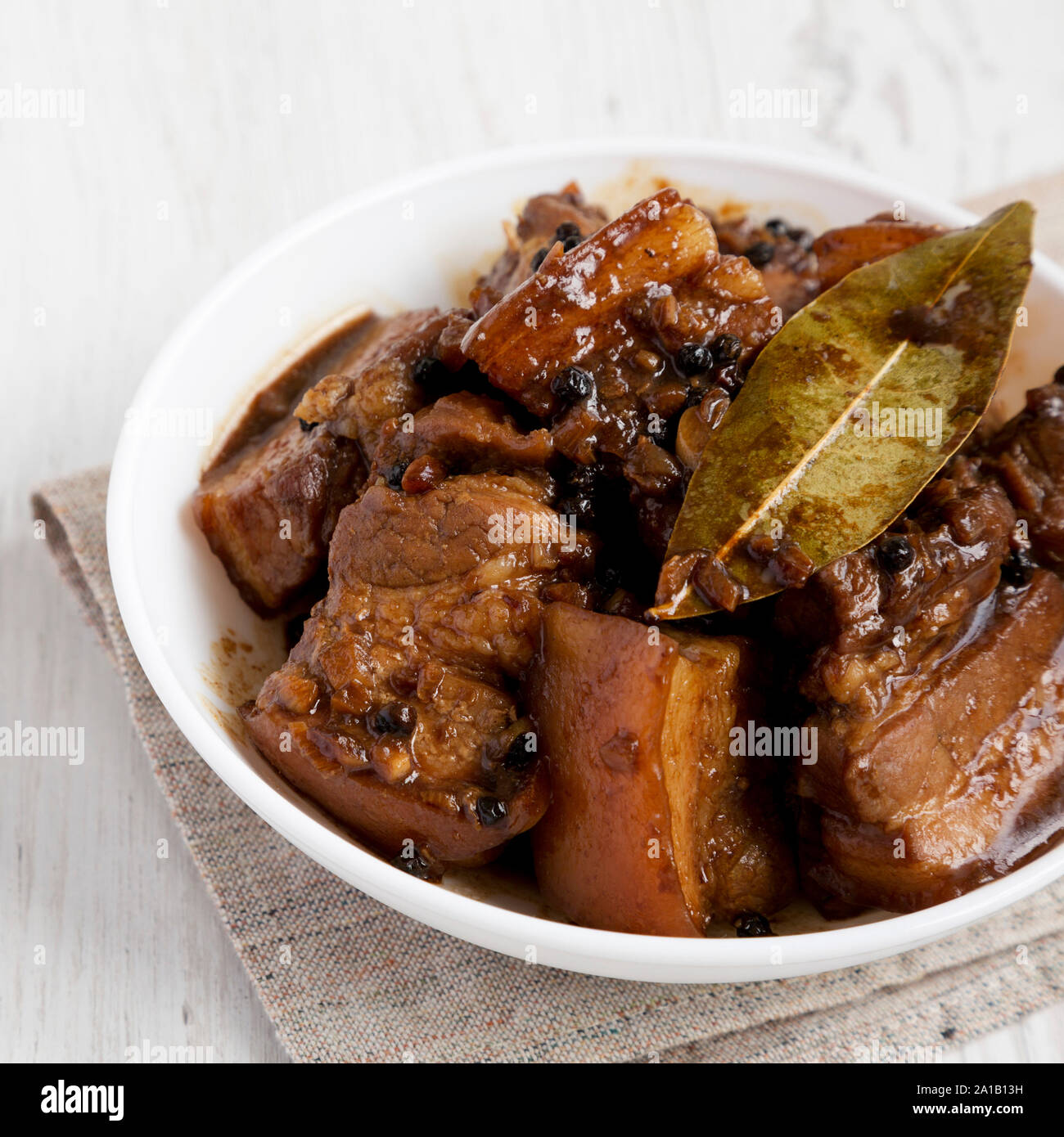 Homemade Filipino Adobo Pork in a bowl on a white wooden background ...