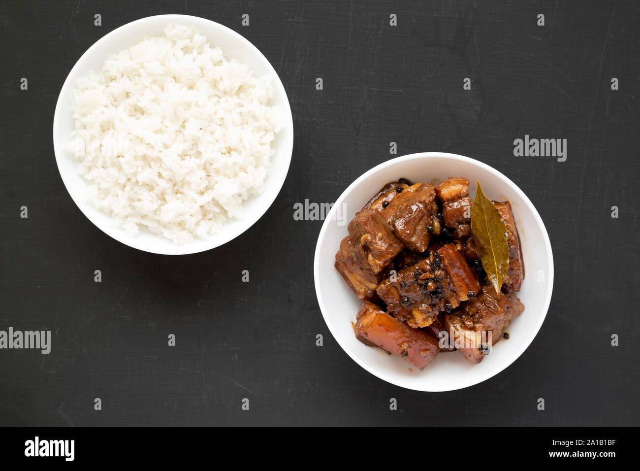 Homemade Filipino Adobo Pork with rice on a black wooden background ...