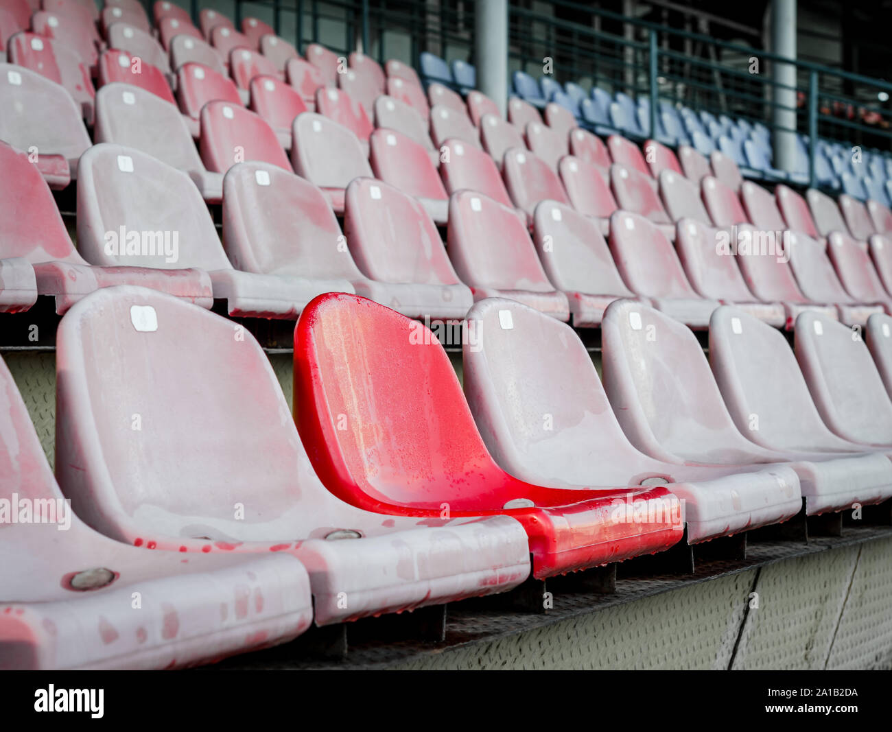 emphasis on one unlike chair among the rows of seats in the empty ...