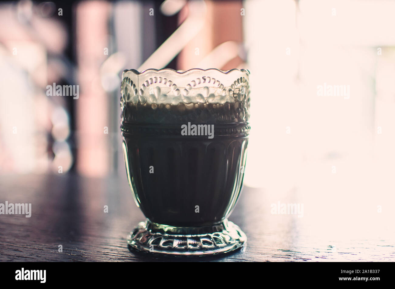 Latte coffee in an unusual glass with antique patterns. American in ...