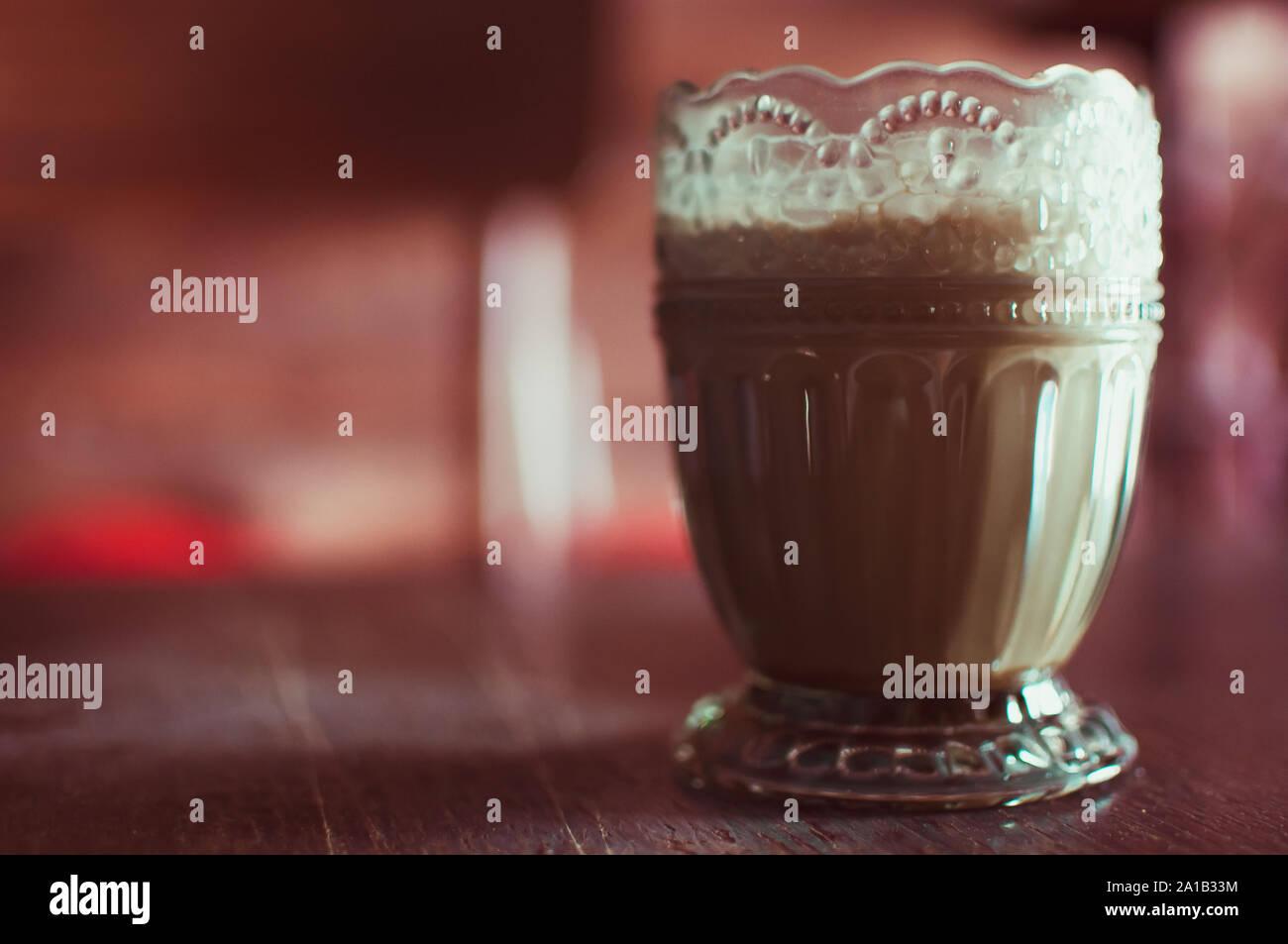 Latte coffee in an unusual glass with antique patterns. American in ...