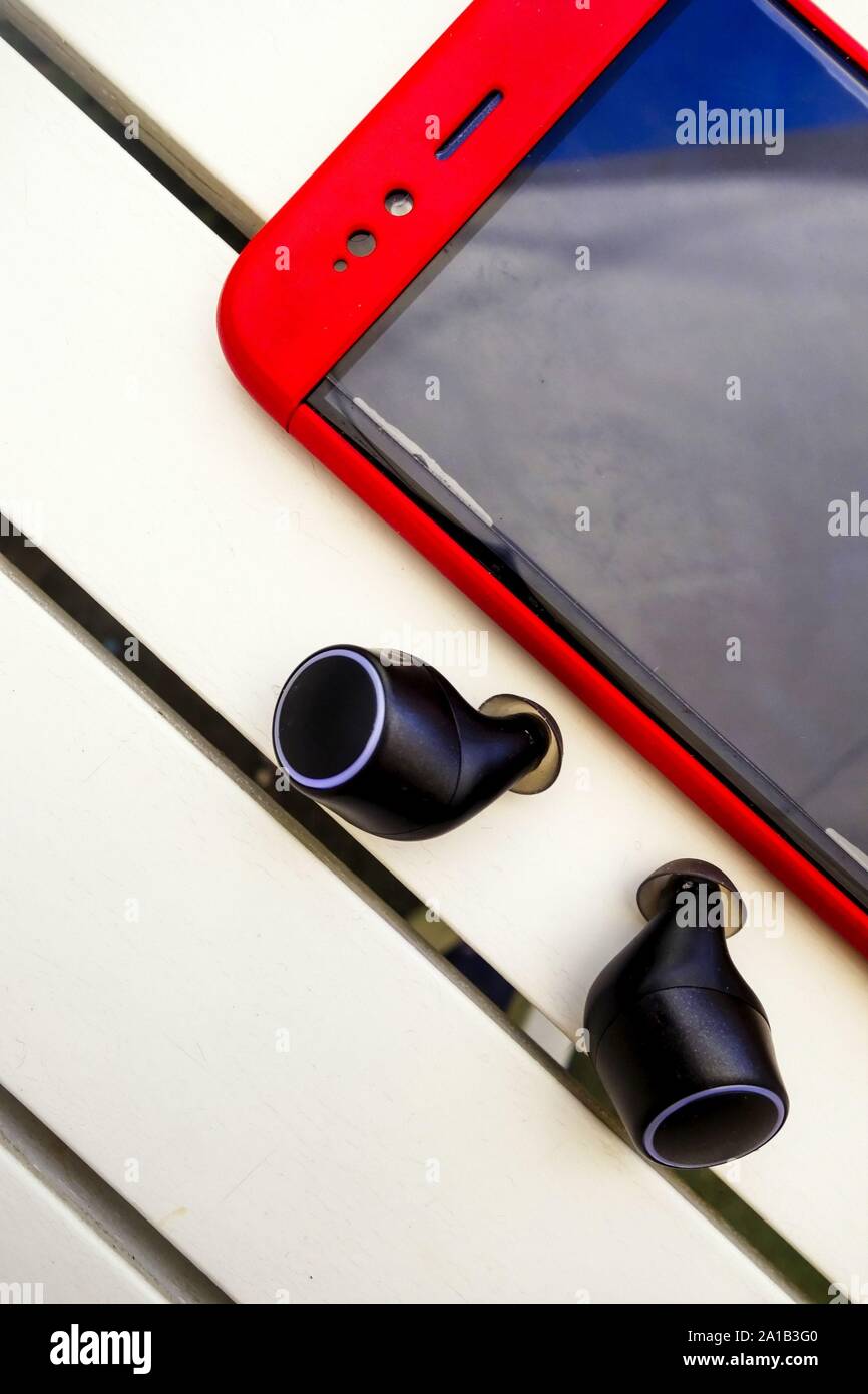 Wireless earbuds or earphones and Mobile Phone Stock Photo - Alamy