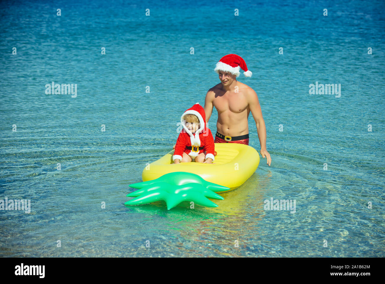 Santa child, father at Christmas. New year muscular man with small boy ...