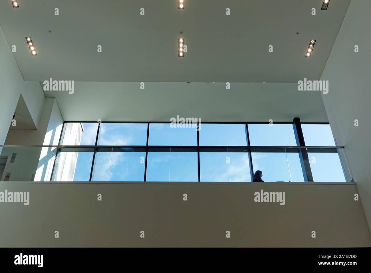 Blue sky with white clouds framed by a paned window inside a modern ...