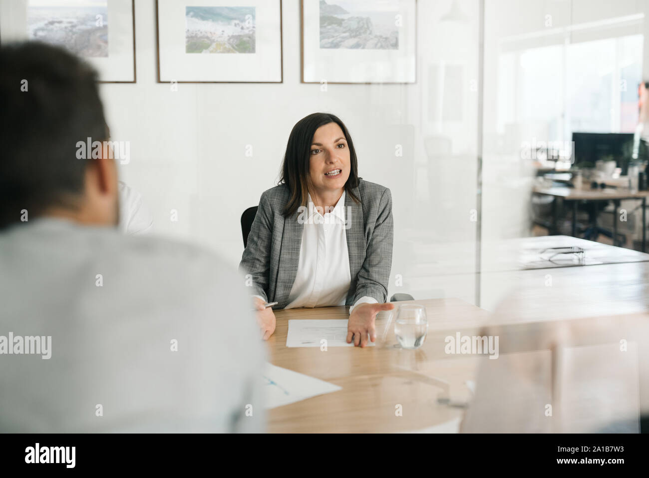 Manager talking with employees at her office desk Stock Photo - Alamy