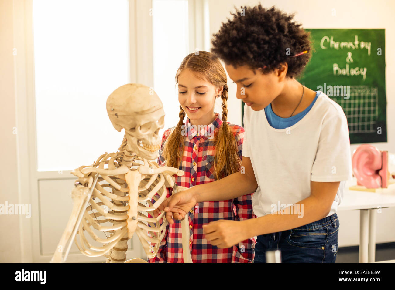 Cheerful children standing in the middle of classroom Stock Photo - Alamy