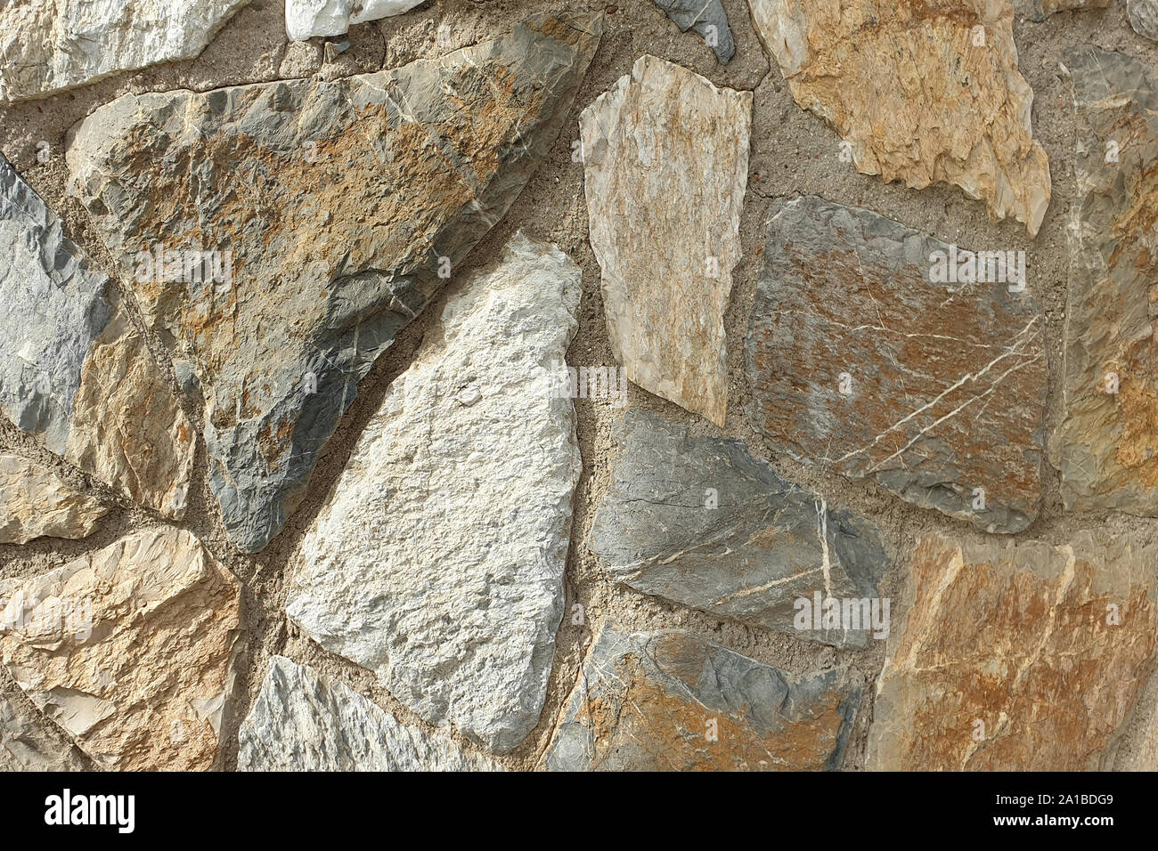 A stone wall of raw stone. Texture of stone Stock Photo - Alamy