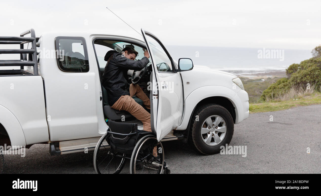 Disabled man getting out of a car into a wheelchair Stock Photo - Alamy