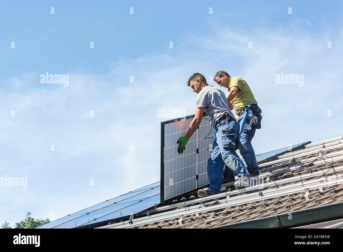 Installing solar photovoltaic panel system. Solar panel technician installing solar panels on ...