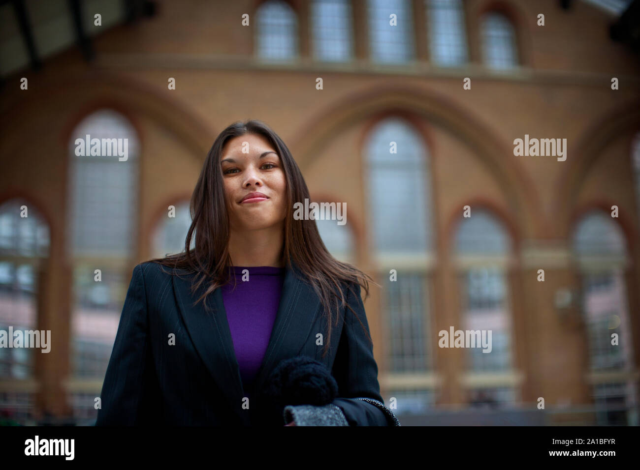 Woman poses for a portrait as she stands outside a grand building Stock ...