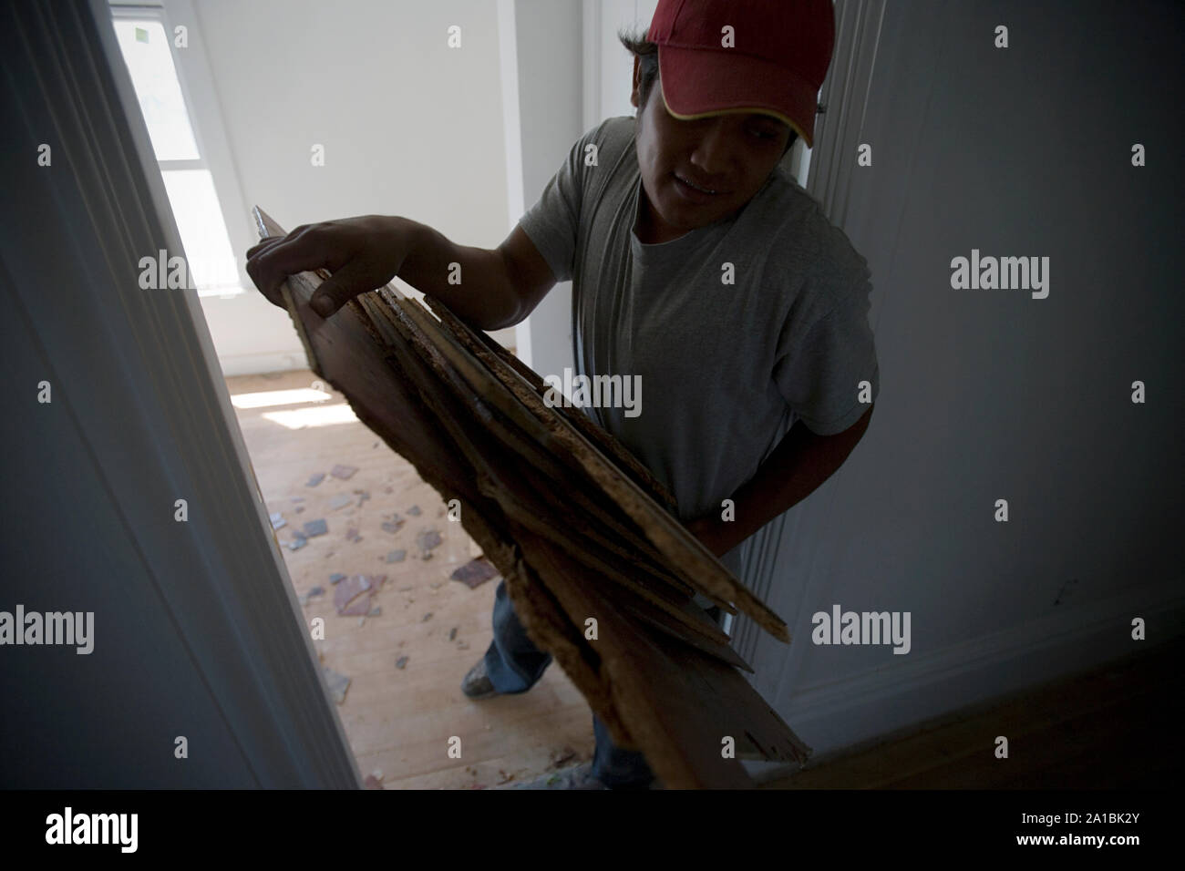Male builder carrying old materials out of a room Stock Photo - Alamy