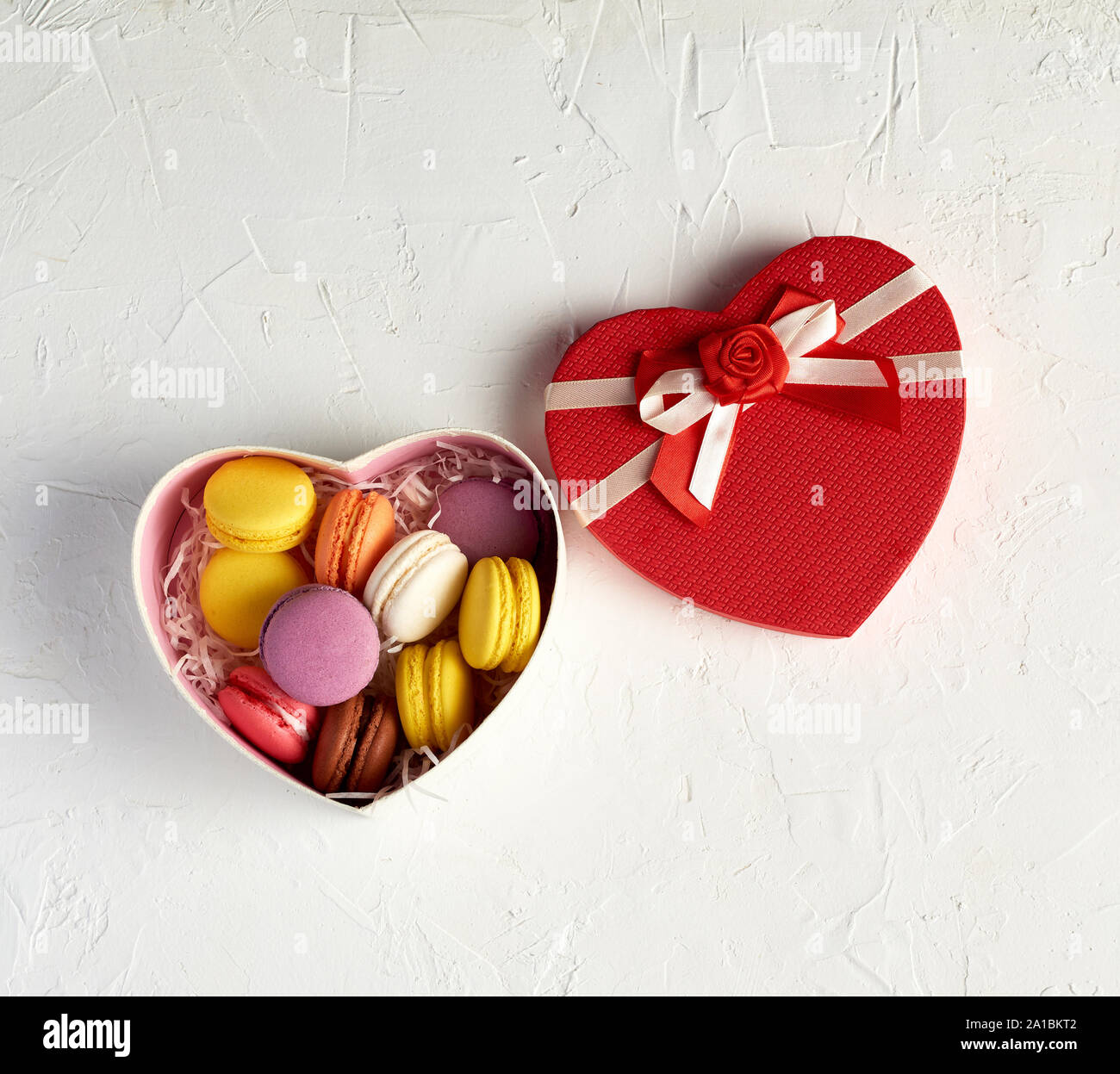 open cardboard box with a baked dessert multi-colored round macarons ...