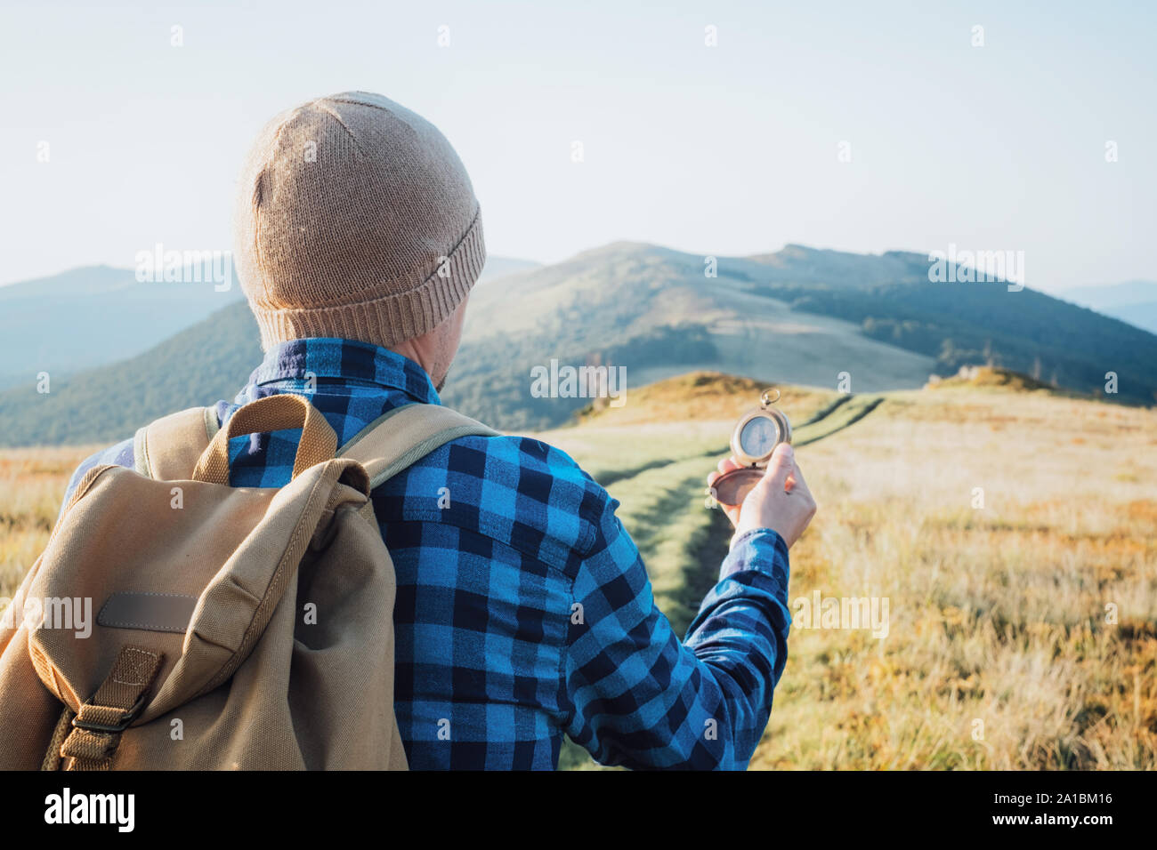 Tourist with compass in hand on mountains road. Travel concept ...