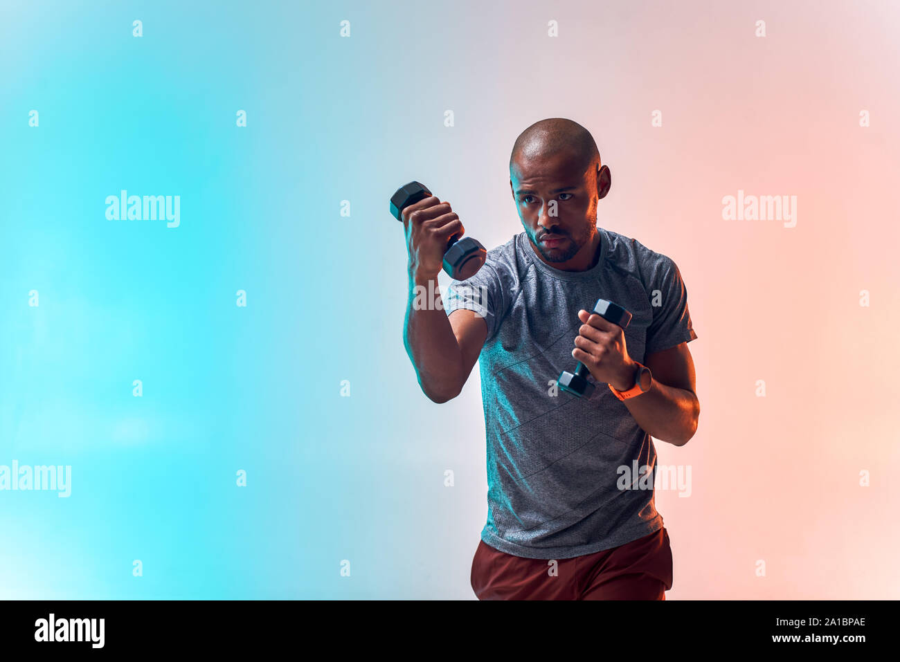 Great workout. Muscular young african man exercising with dumbbells ...