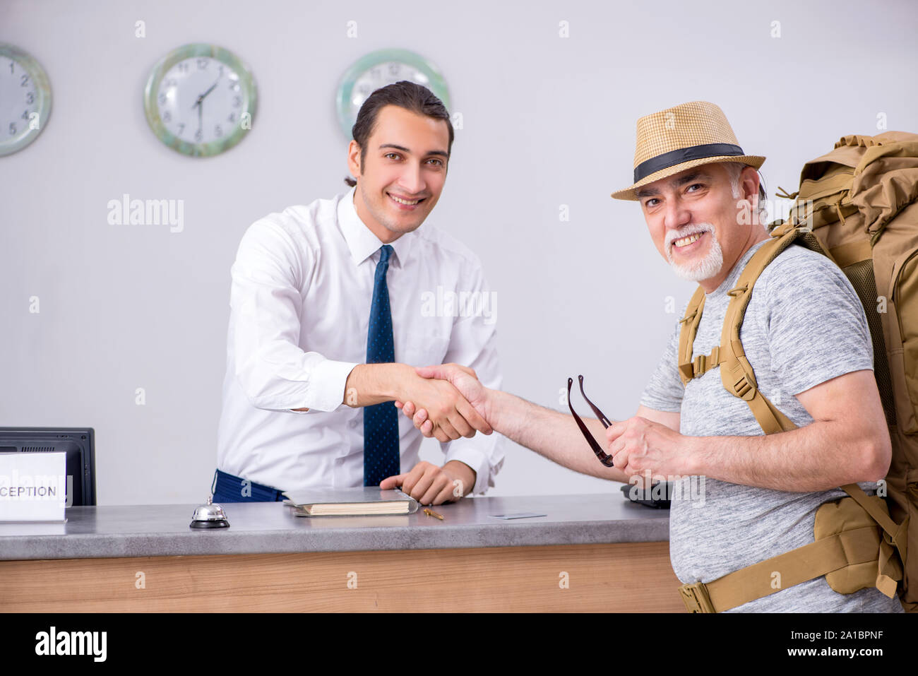 Old backpacker at the hotel reception Stock Photo - Alamy