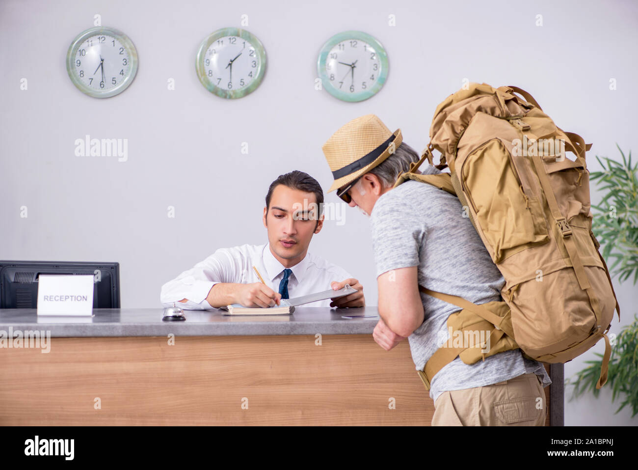 Old backpacker at the hotel reception Stock Photo - Alamy