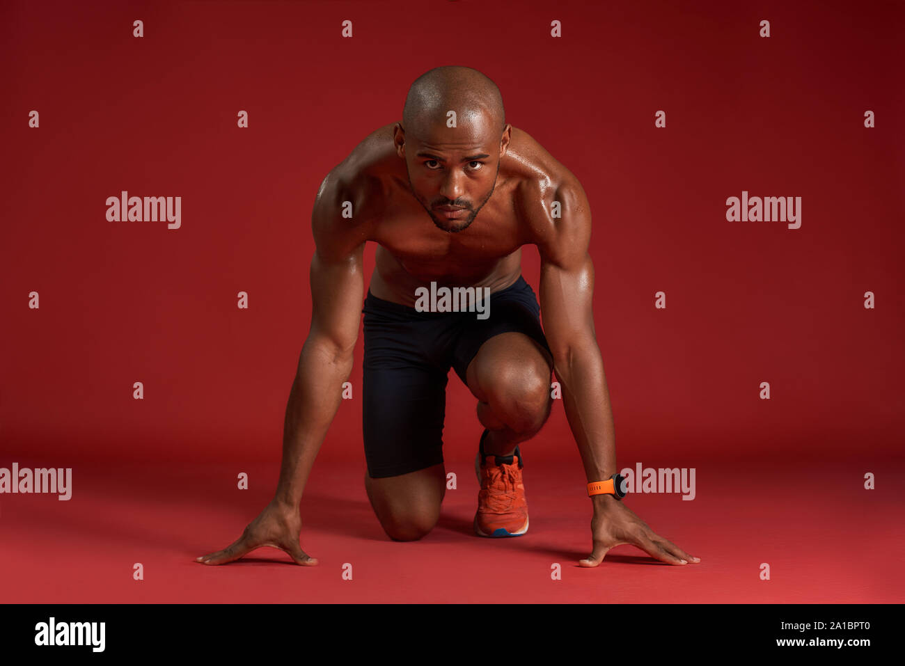 Portrait of young african man in sportswear going to run while sitting ...
