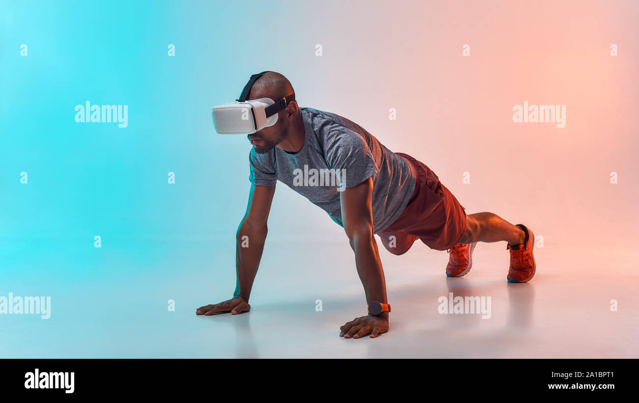 VR technology. Full length of young african man in sports clothing ...