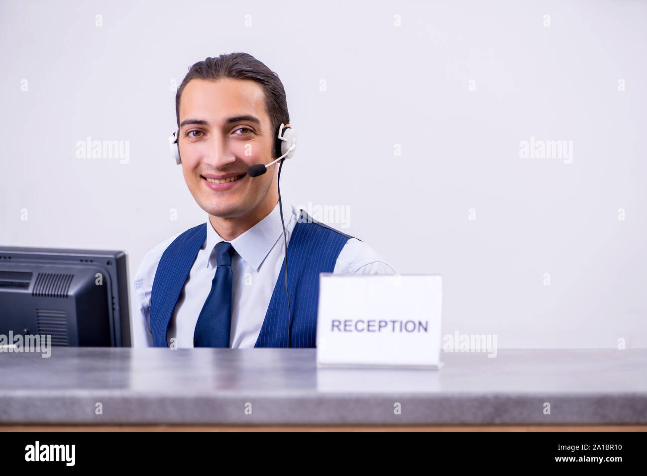 The young man receptionist at the hotel counter Stock Photo - Alamy