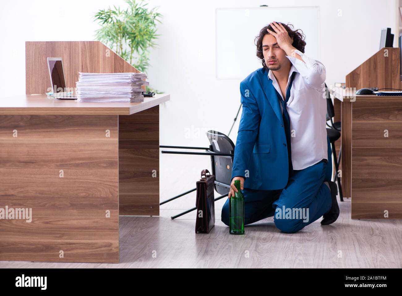 The young drunk employee in the office Stock Photo - Alamy