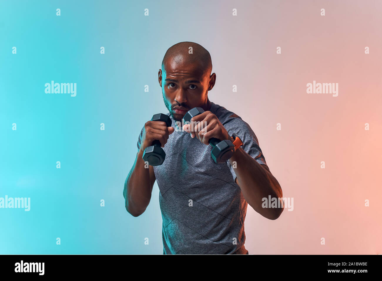 Work hard Muscular young african man exercising with dumbbells while ...