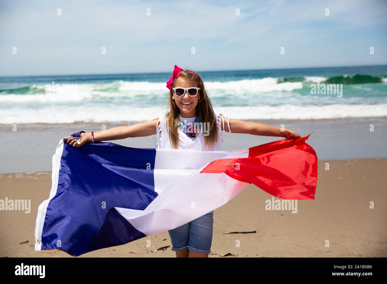 Happy French girl carries fluttering blue white red French flag of ...