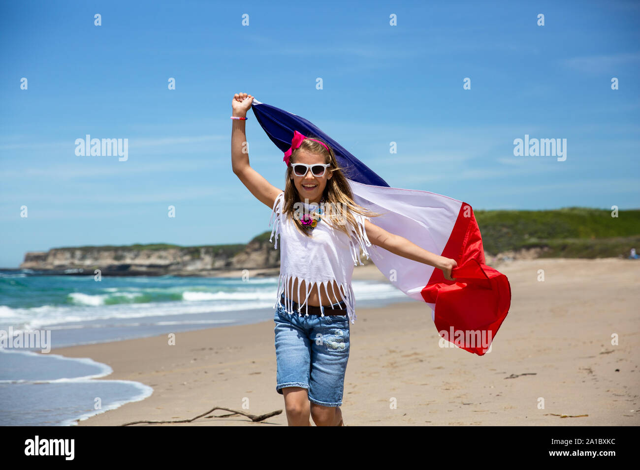 Happy French girl carries fluttering blue white red French flag of ...