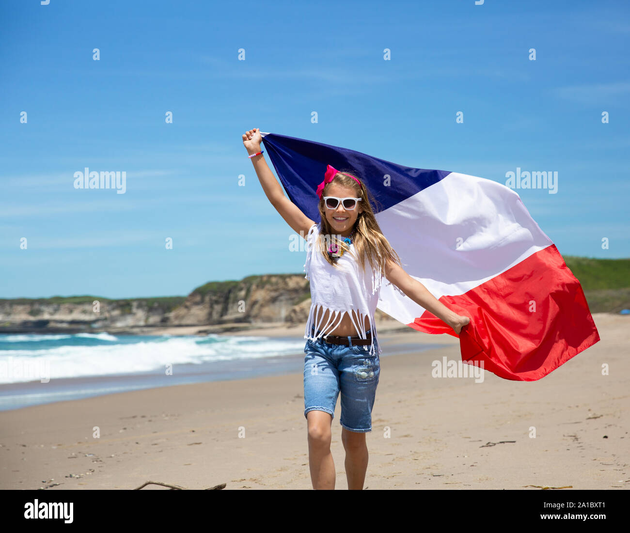 Happy French girl carries fluttering blue white red French flag of ...
