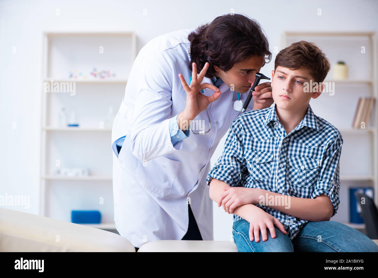 The male otolaryngologist examining boy's ear Stock Photo - Alamy