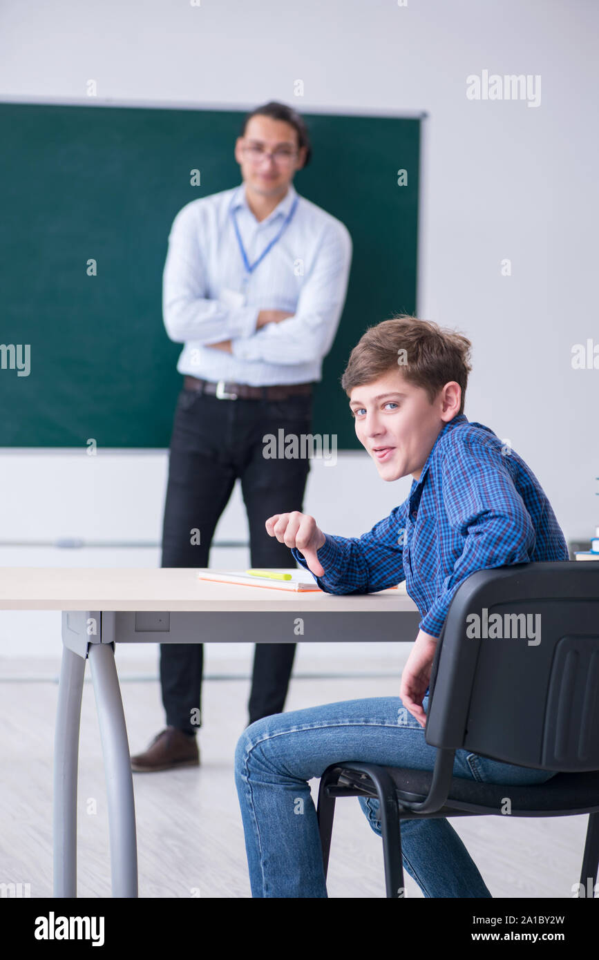 The young male teacher and boy in the classroom Stock Photo - Alamy