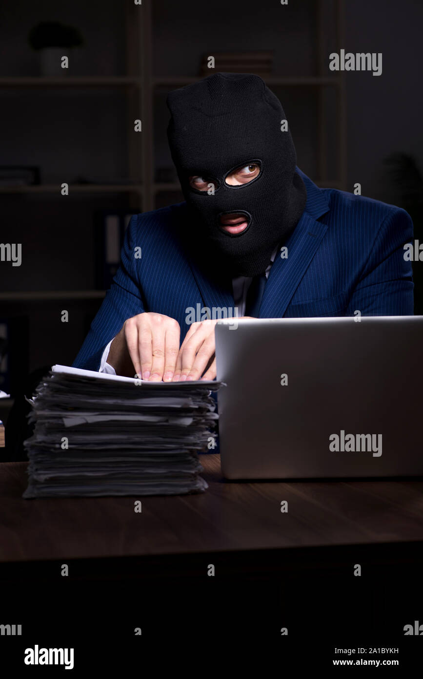 The male employee stealing information in the office night time Stock ...
